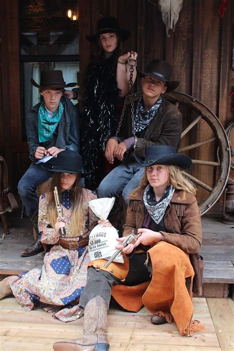 Several People Dressed In Western Clothing Sitting On The Porch With