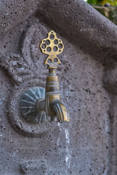 Water Flows From An Old Copper Faucet A Vertical Shot Stock Photo By