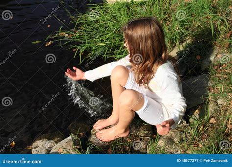 Fille S asseyant Par Une Rivière Image stock Image du pieds