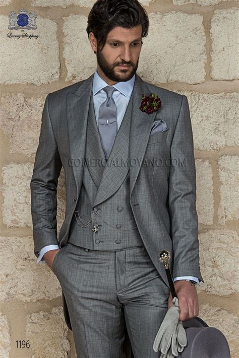 A Man In A Suit And Hat Standing Next To A Brick Wall