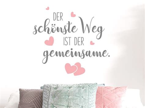 A Bedroom With A Bed Pillows And Wall Decal That Says Der Schnoste We