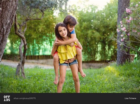 Girl Carrying Boy On Her Back Stock Photo OFFSET
