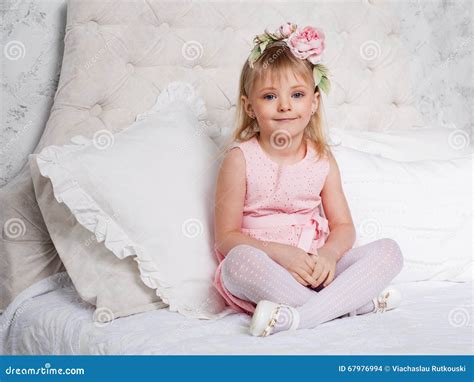 Portrait D Une Petite Fille Blonde S Asseyant Sur Le Lit Dans La
