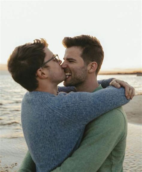 Two Men Hugging Each Other On The Beach