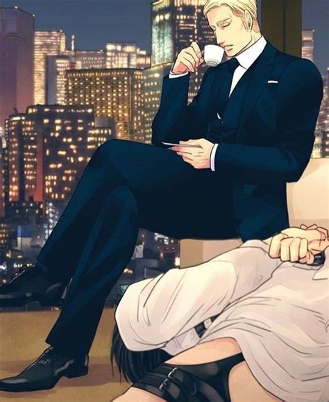A Man In A Suit And Tie Sitting On A Chair Next To A Woman Holding A Cup