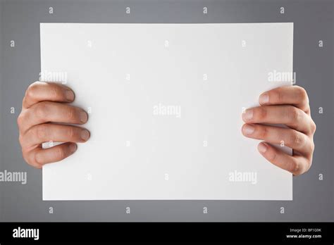 Hands Holding Up A White Piece Of Paper Stock Photo Alamy