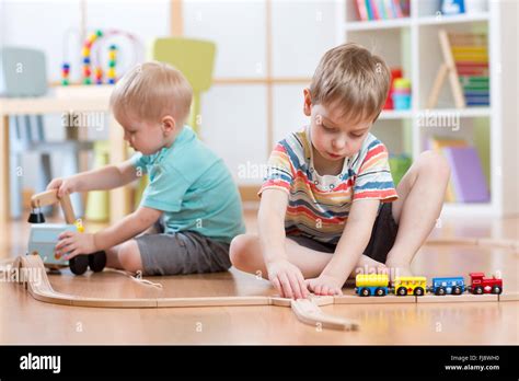 Los niños juegan con juguetes educativos y la construcción de la vía