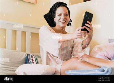 Beautiful Woman Applying Facial Mask And Using Mobil Phone Stock Photo
