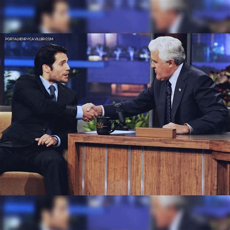Two Men In Suits Shaking Hands On The Set Of An Interview With Host