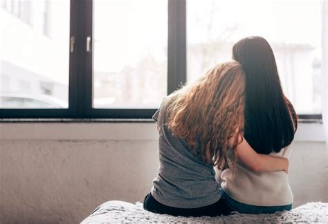 Couple De Lesbiennes Embrassant Près De La Fenêtre Photo Gratuite