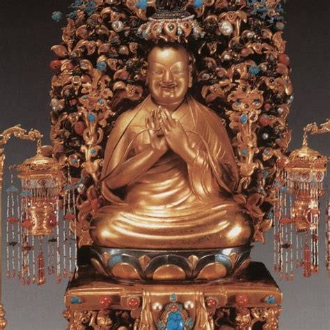 A Golden Buddha Statue Sitting On Top Of A Table