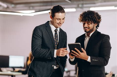 Compañeros De Trabajo Riendo Mirando La Pantalla De La Tableta Captura Interior De Dos Amigos De