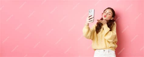 Premium Photo Beautiful Flirty Girl Taking Selfie On Smartphone Sending Air Kiss During Video