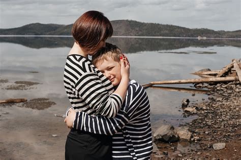Maman embrasse son fils au bord de la rivière Une belle mère moderne