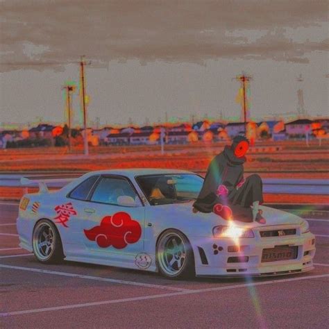 A Person Sitting On Top Of A White Car In A Parking Lot With Other Cars
