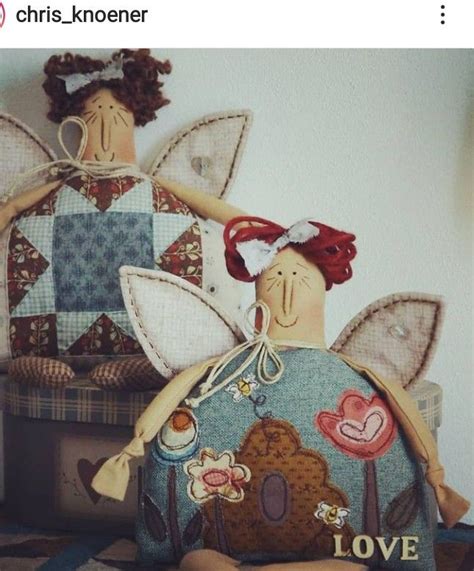 Two Dolls Sitting Next To Each Other On Top Of A Bed