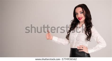 Photo de stock Une étudiante joyeuse montre son pouce 1774936562