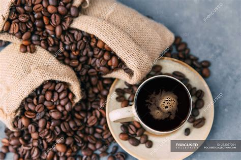 Coffee Cup And Coffee Beans Over Table Cuisine Bags Stock Photo
