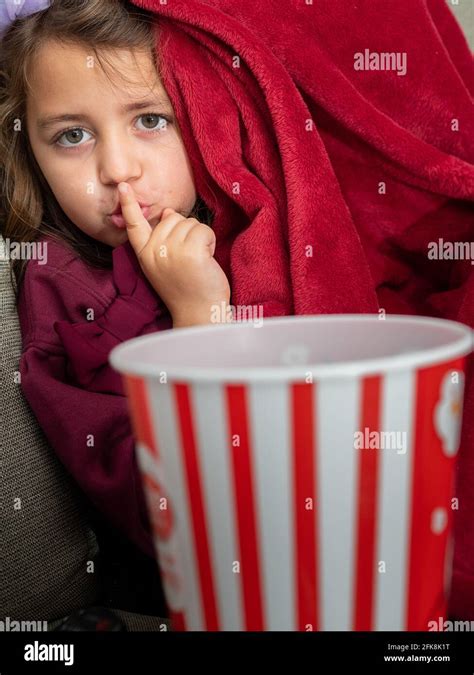 Latina Girl Making The Silent Gesture With Her Finger Covering Herself With A Blanket Stock
