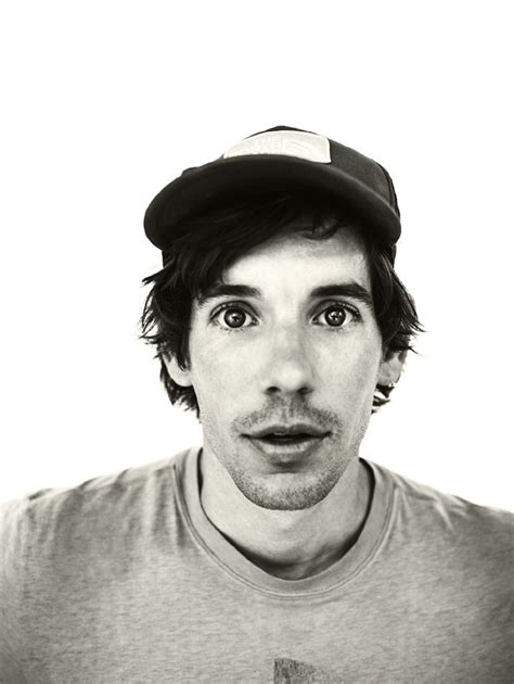 A Black And White Photo Of A Man With A Hat On His Head Looking At The