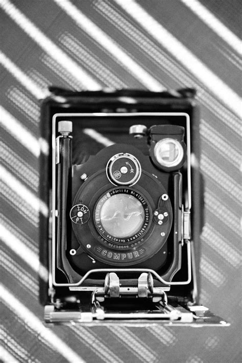 An Old Fashioned Camera Sitting On Top Of A Table