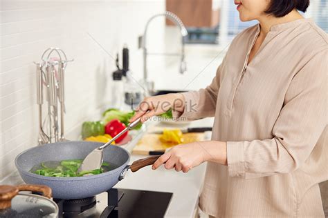 ảnh Hình ảnh Người Phụ Nữ Trung Niên Tóc Ngắn đang Nấu ăn Trong Bếp Tải