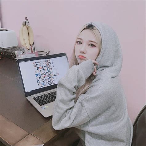 A Woman Sitting In Front Of A Laptop Computer On Top Of A Wooden Desk