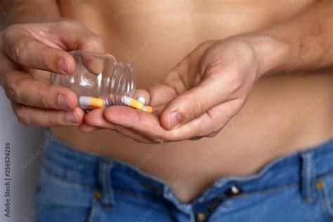 Man Taking Pills Bottle With Capsules In Male Hands Close Up Muscular