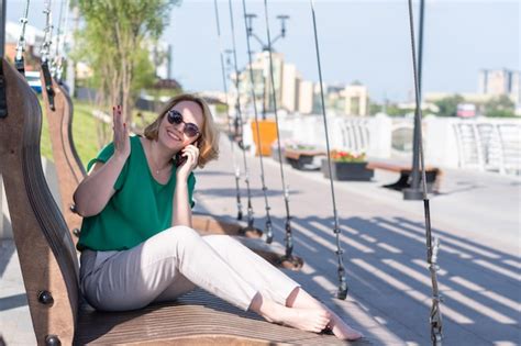 Retrato De Una Mujer De Mediana Edad Sonriente Con Gafas De Sol Sentada