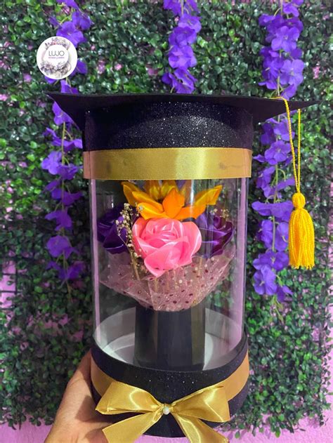 A Graduation Cap With Flowers In It And A Tassel Hanging From The Top