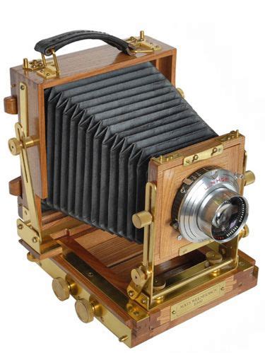An Old Fashioned Camera Sitting On Top Of A Wooden Stand