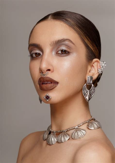 Profile Of A Beautiful Young Woman With Make Up With Silver Bijouterie Looking At Camera