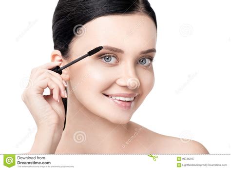 Naked Brunette Woman Applying Mascara And Smiling At Camera Stock Image