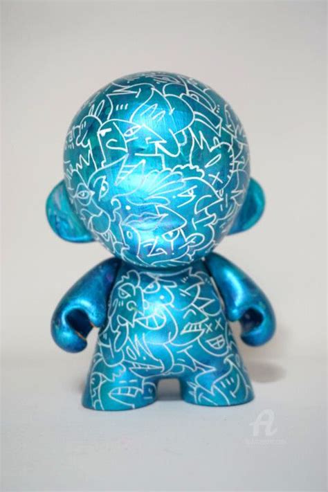 A Close Up Of A Small Toy On A White Surface With Blue And Green Paint