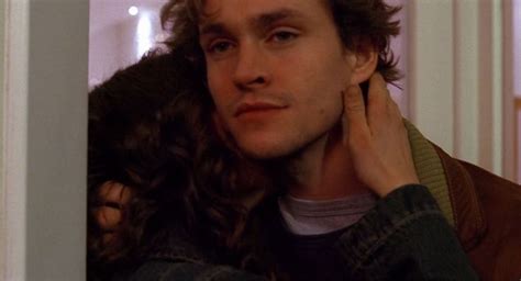 A Man With Long Hair Is Holding His Hand On His Shoulder