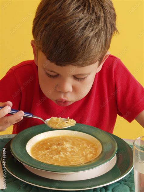 Niño comiendo sopa con fideos niño almorzando Stock Photo Adobe Stock