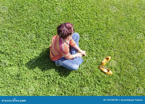 Fille Aux Pieds Nus S asseyant Sur L herbe à Côté De Ses Chaussures