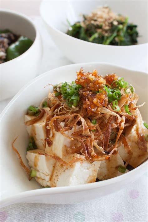 Two White Bowls Filled With Food On Top Of A Table