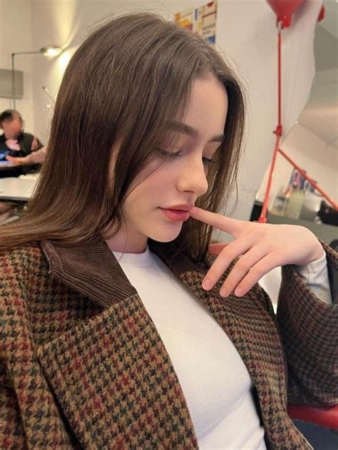 A Woman Sitting At A Desk With Her Hand On Her Chin