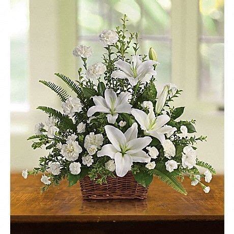 A Basket Filled With White Flowers On Top Of A Wooden Table