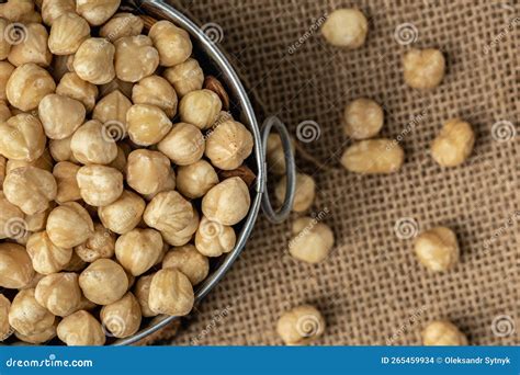 A Pile Of Peeled Hazelnuts In A Metal Bowl On The Burlap Background