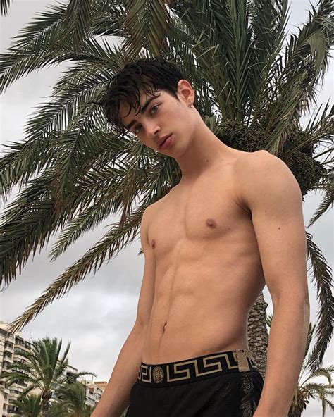 A Shirtless Man Standing In Front Of A Palm Tree With No Shirt On