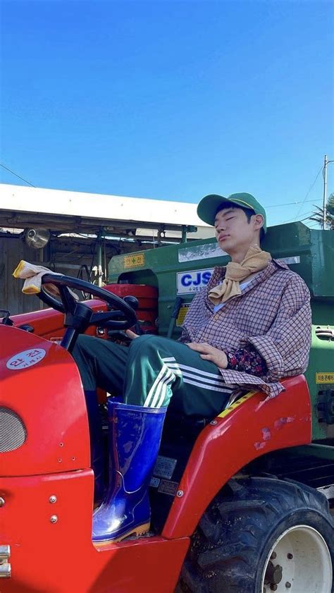 A Man Sitting On The Back Of A Red Tractor