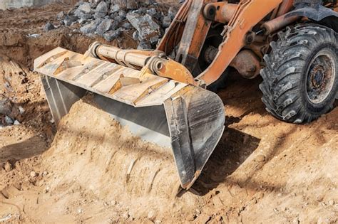 La retroexcavadora mueve el suelo arcilloso de la excavación al