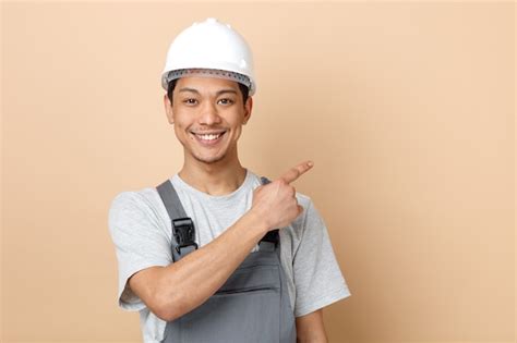 Sonriente joven trabajador de la construcción con casco de seguridad y