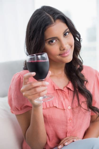 Premium Photo Smiling Cute Brunette Sitting On Couch Holding Wine Glass