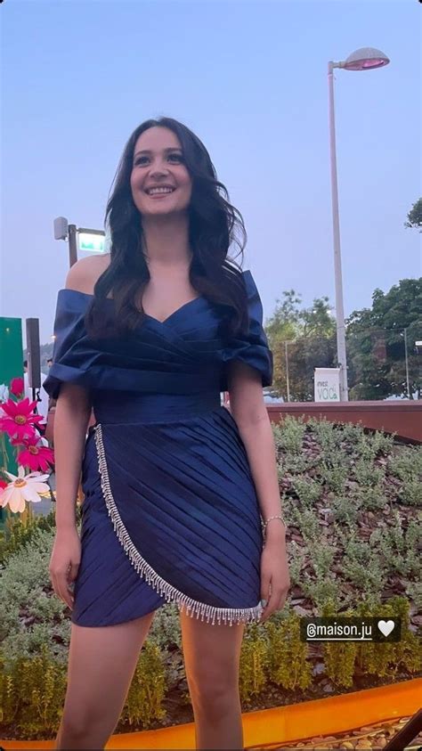 A Woman In A Blue Dress Posing For The Camera With Her Hand On Her Hip
