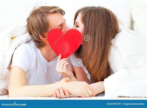 Couples D Amant Embrassant Avec Un Coeur Rouge Dans Le Lit Image Stock