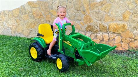 Dima en un tractor ayuda a la pequeña Alice Dima quiere ser un buen