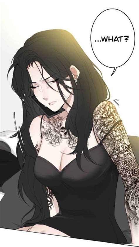 A Woman With Tattoos On Her Arm Sitting Down